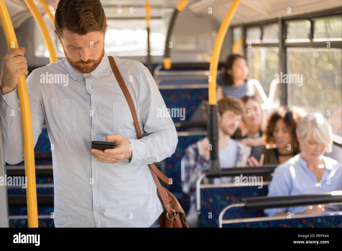 Male commuter using mobile phone while travelling in modern bus Stock ...