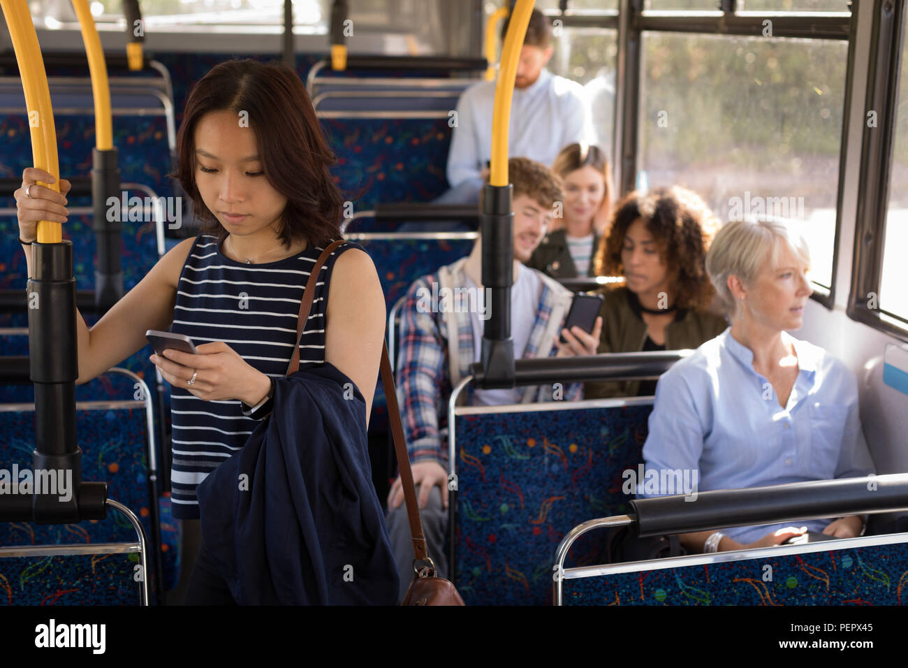 Female commuter using mobile phone while travelling in modern bus Stock ...