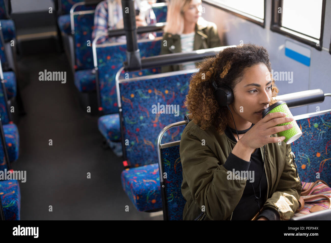 Female commuter having coffee while travelling in modern bus Stock ...