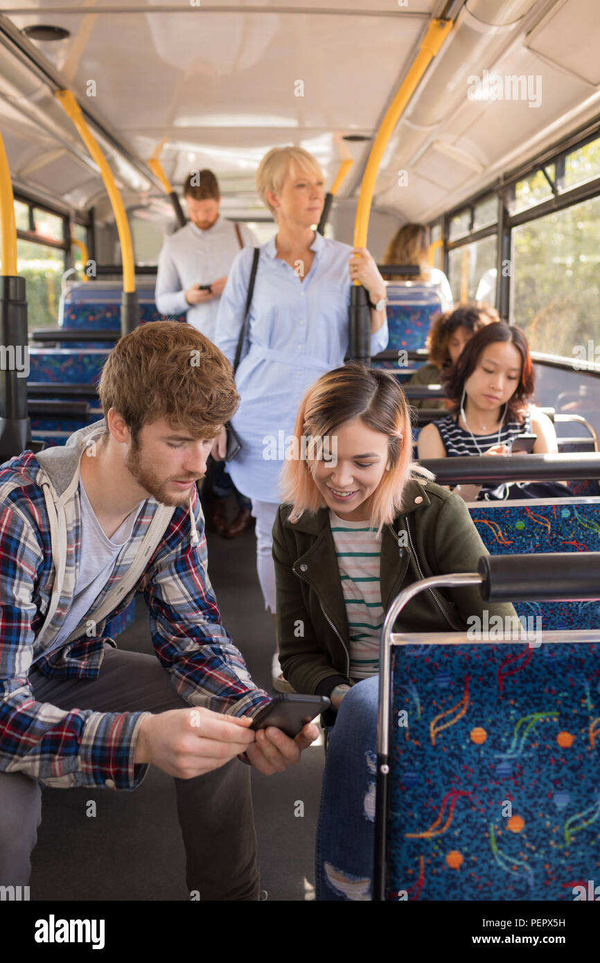 Couple using mobile phone while travelling in modern bus Stock Photo ...