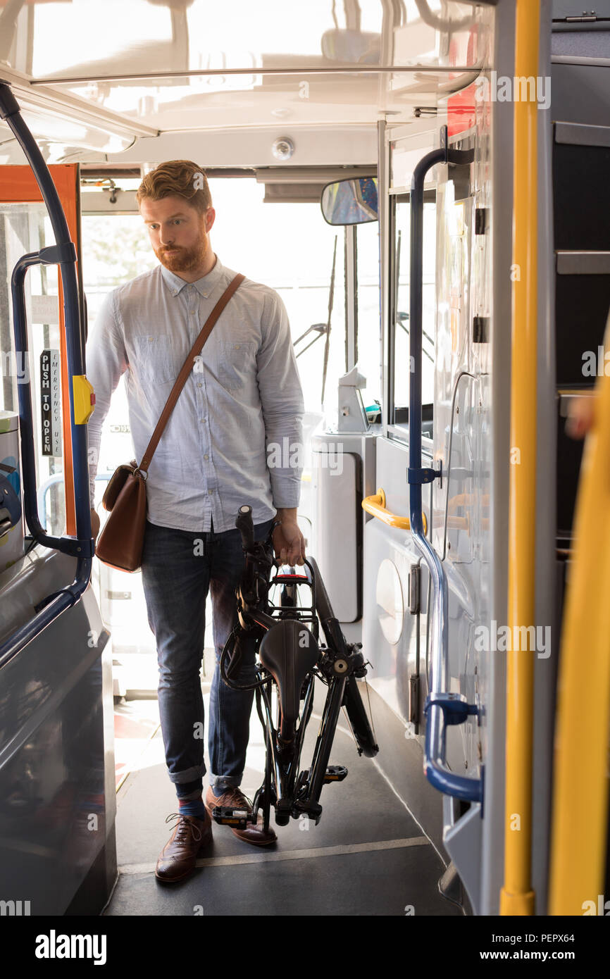 Man with folding bicycle entering in modern bus Stock Photo - Alamy