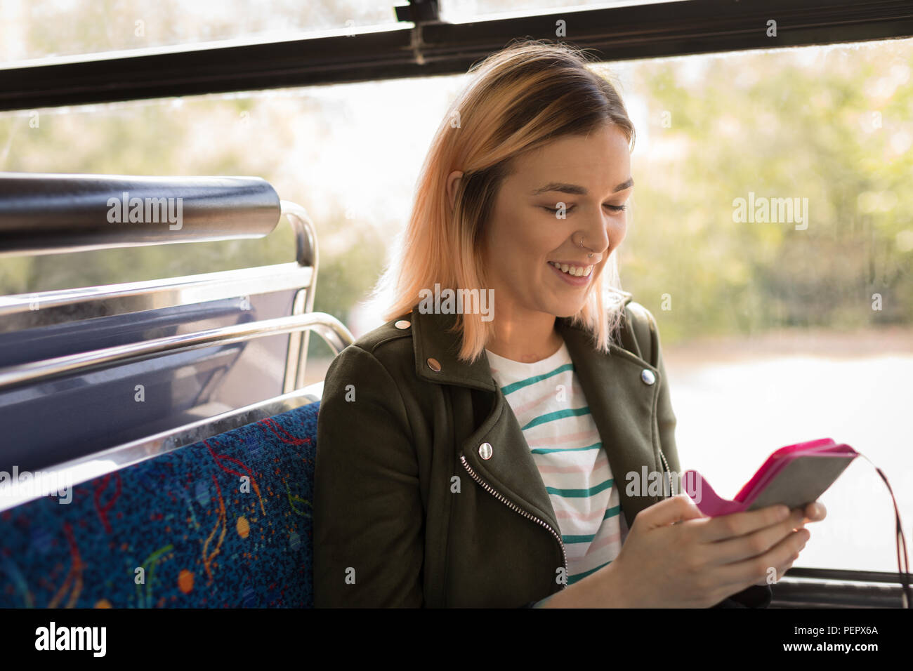 Female commuter using mobile phone while travelling in modern bus Stock ...