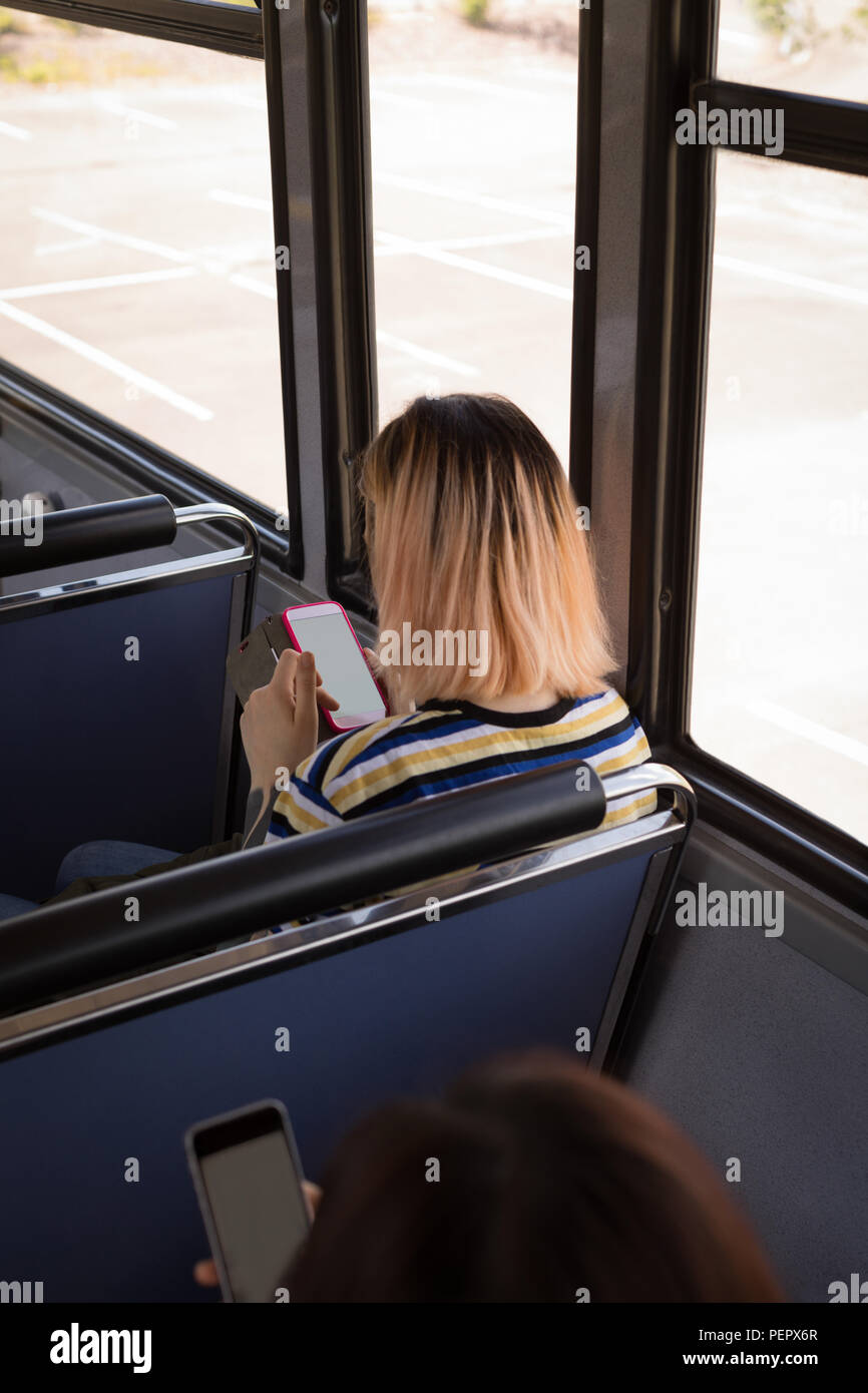 Female commuter using mobile phone while travelling in modern bus Stock ...