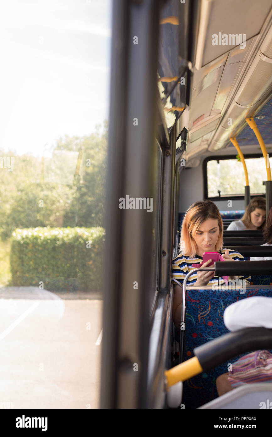 Female commuter using mobile phone while travelling in modern bus Stock ...