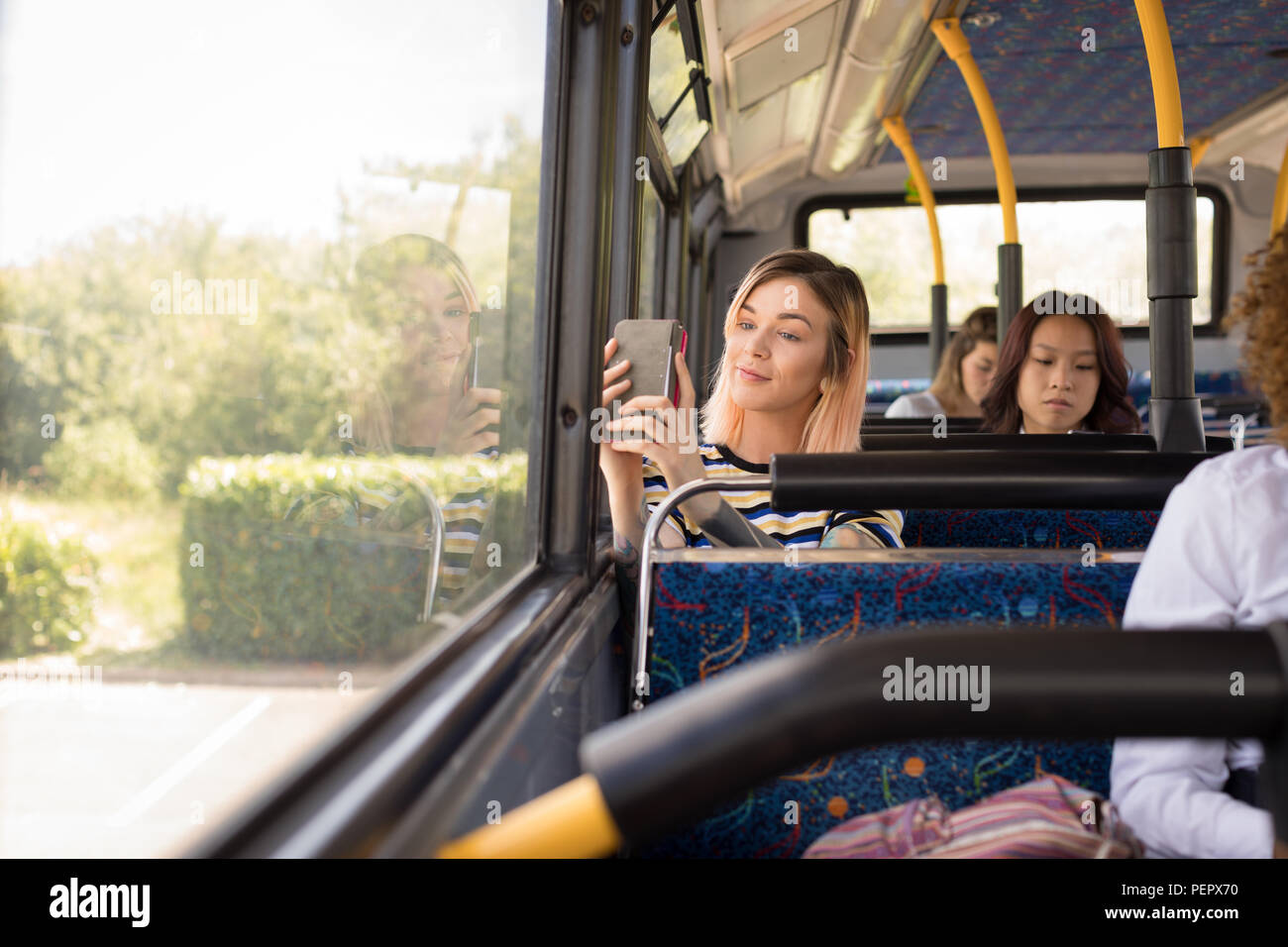 Female commuter taking selfie on mobile phone while travelling in ...