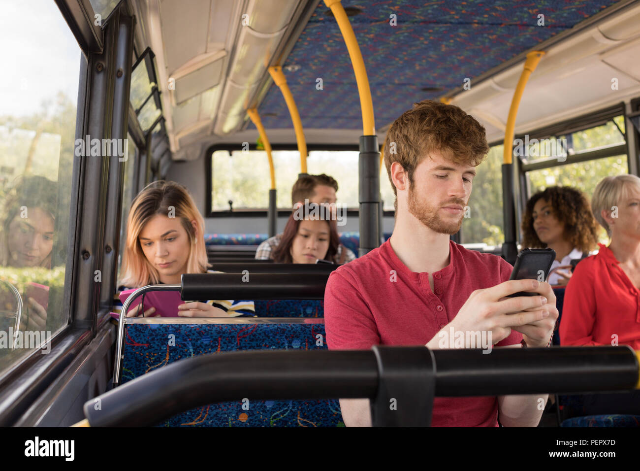 Male commuter using mobile phone while travelling in modern bus Stock ...