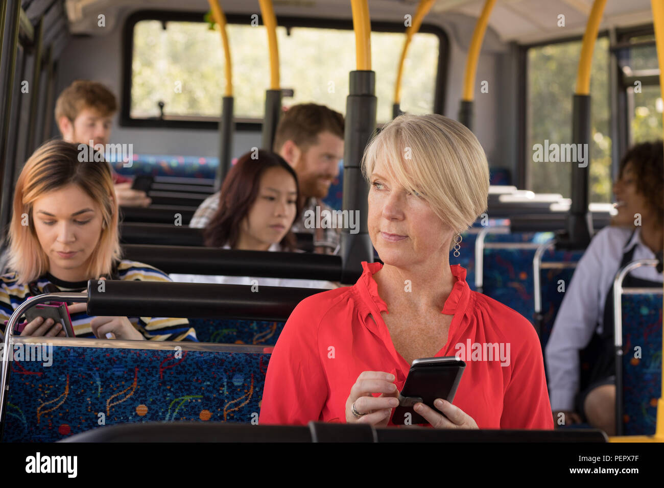 Female commuter using mobile phone while travelling in modern bus Stock ...