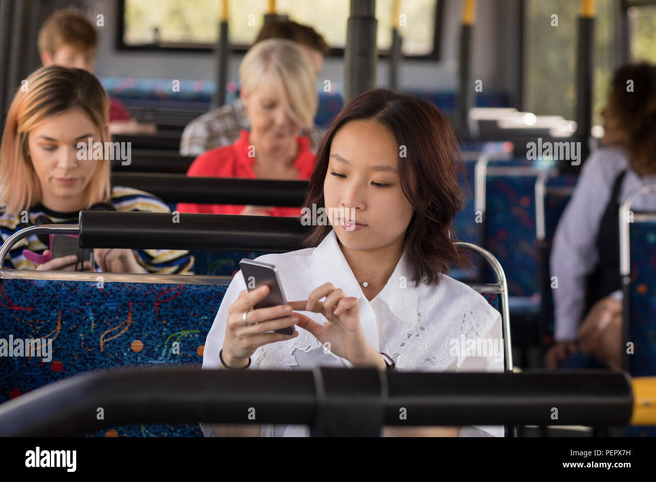 Female commuter using mobile phone while travelling in modern bus Stock ...