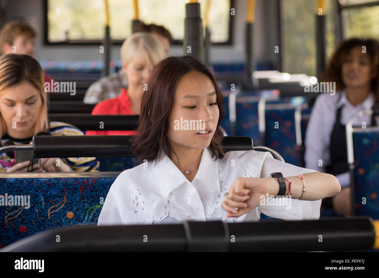 Female commuter checking time while travelling in modern bus Stock ...