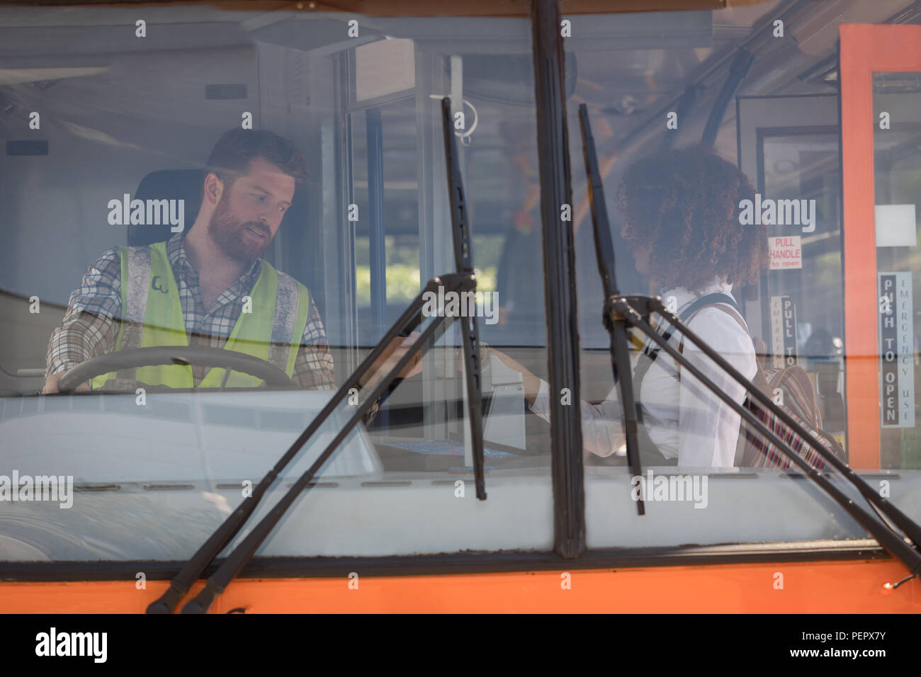 Female commuter taking ticket from driver in modern bus Stock Photo - Alamy