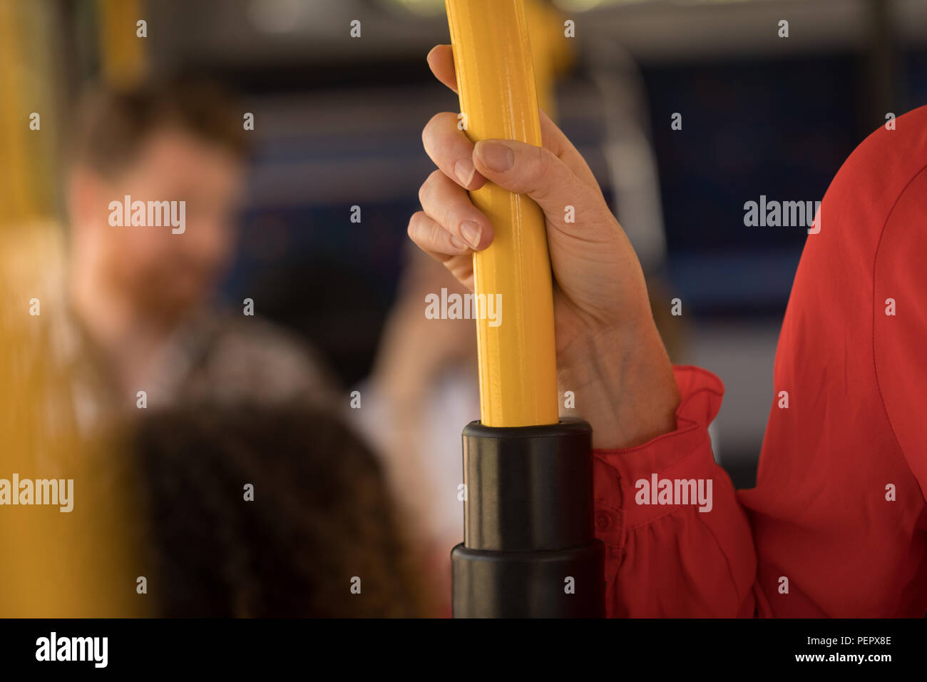 Female commuter holding pole while travelling in modern bus Stock Photo ...