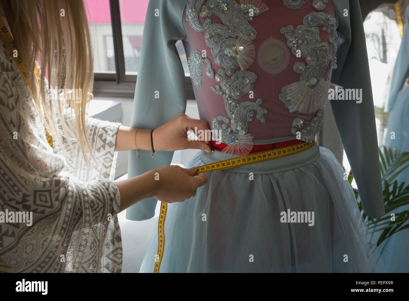 Fashion designers taking measurement of mannequin Stock Photo - Alamy