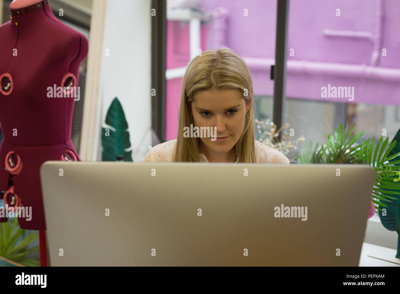 Fashion designer using computer in fashion studio Stock Photo - Alamy