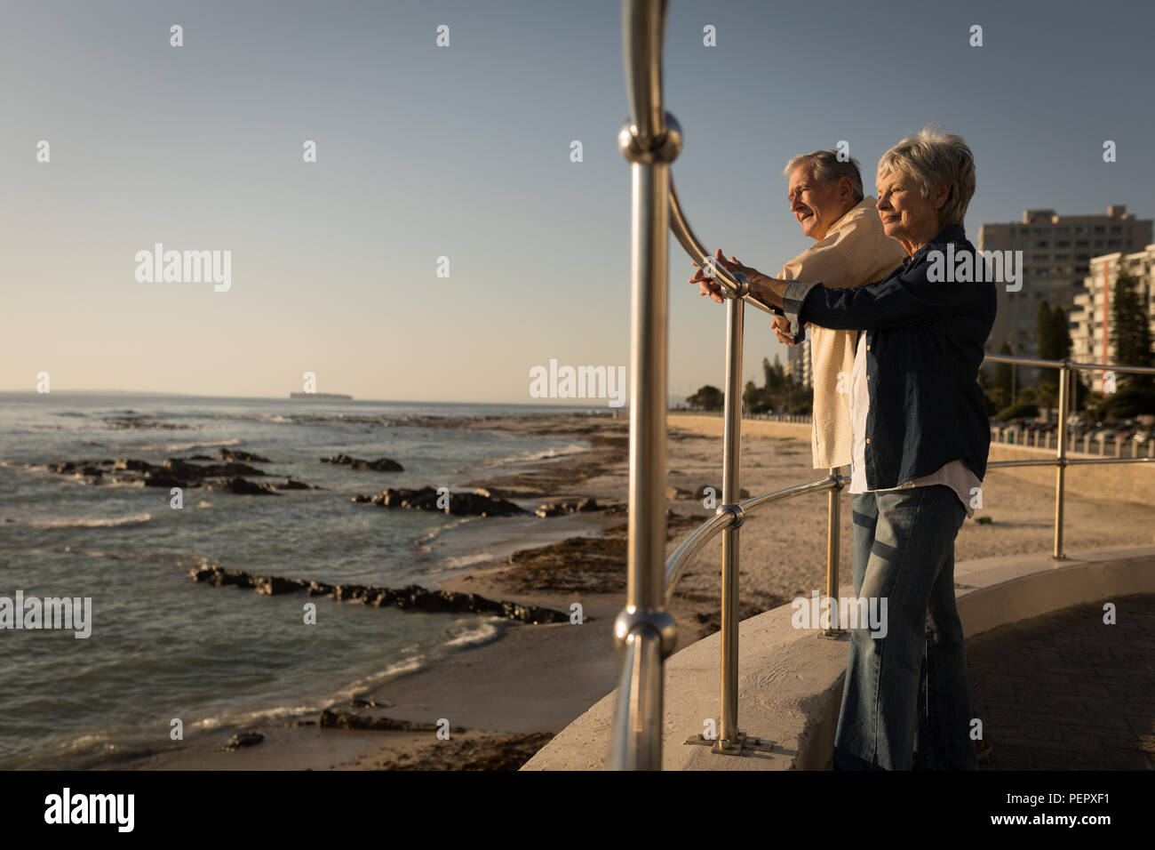 Senior couple standing at promenade near sea Stock Photo - Alamy