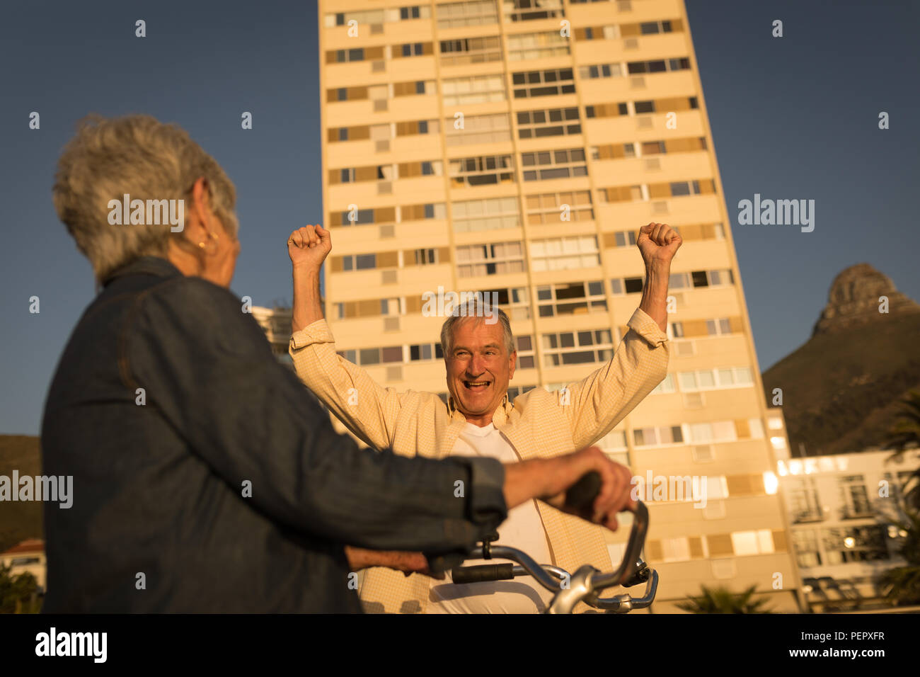 Senior man cheering at promenade Stock Photo - Alamy