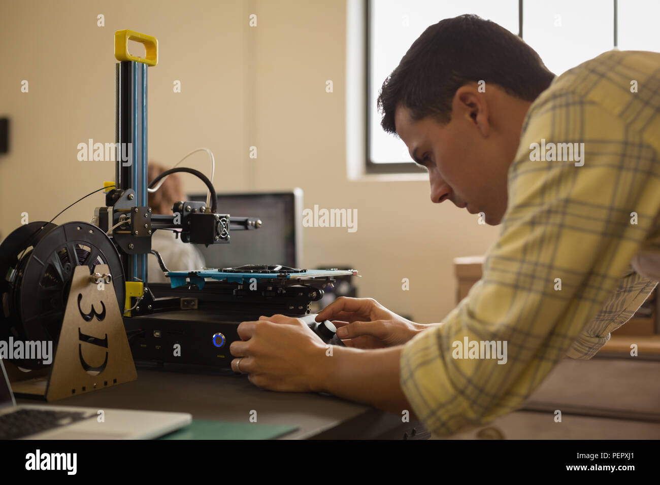 Mechanic using die machine on table Stock Photo - Alamy