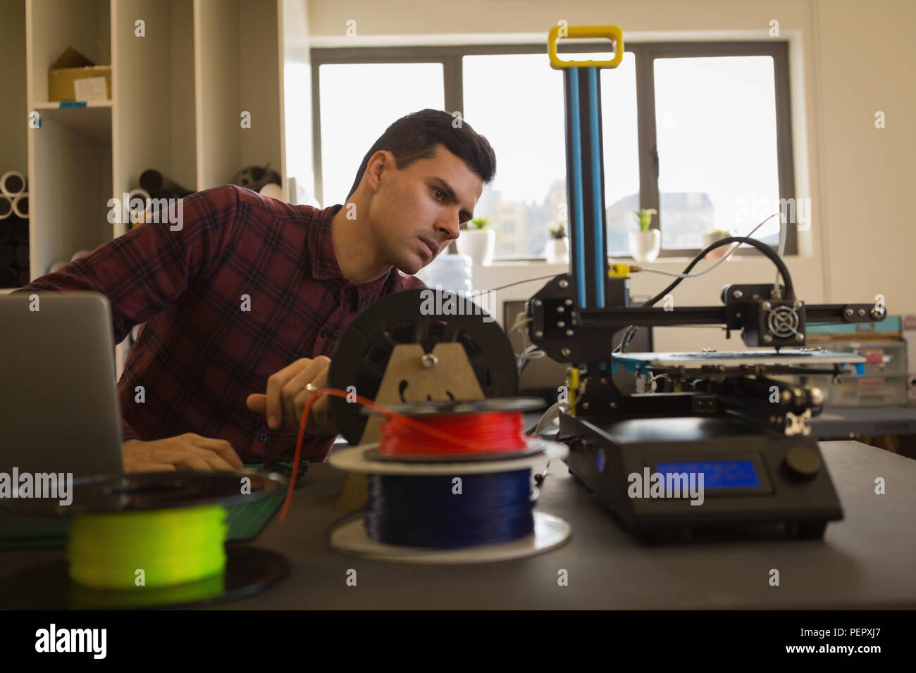 Mechanic looking at die machine on table Stock Photo - Alamy