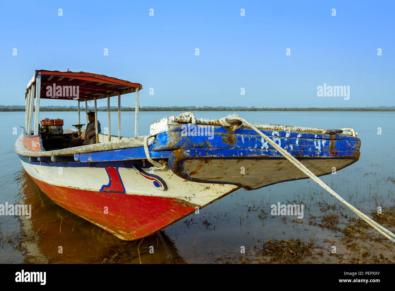 A square front boat tied up to shore beached at West Baray lake Stock ...