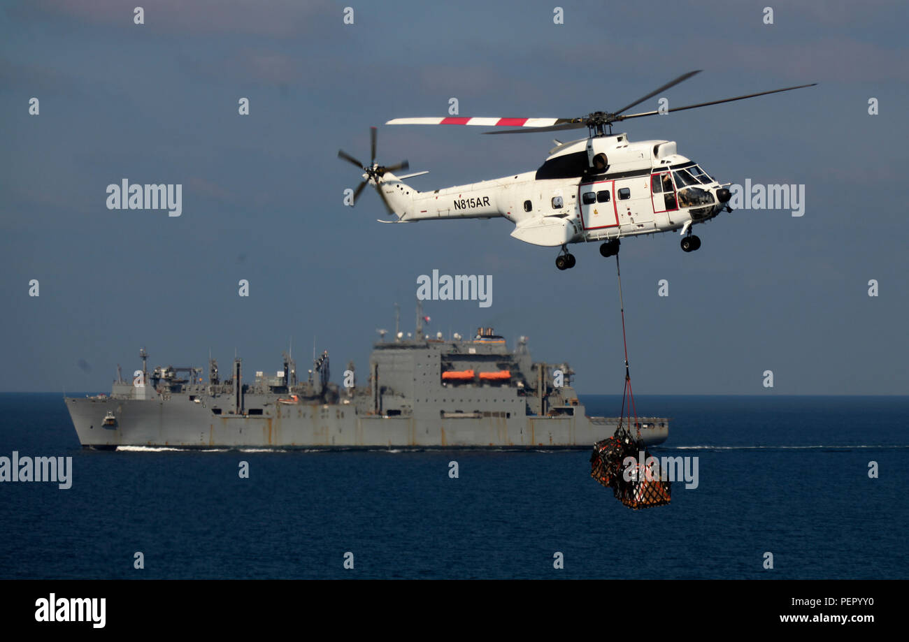 A U.S. Navy transport helicopter delivers pallets of cargo to the USS ...
