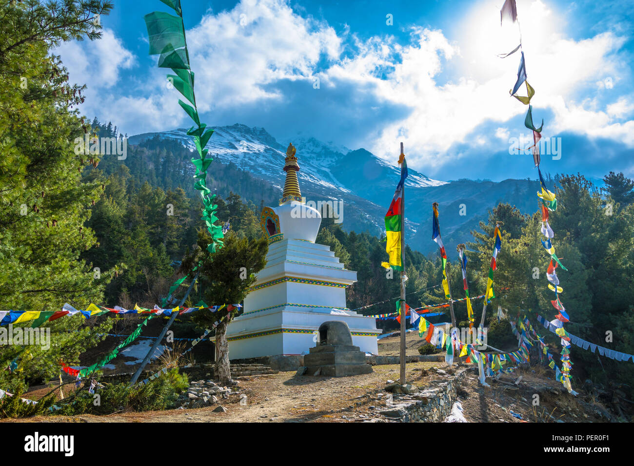 Beautiful white stone stupa against mountains and blue sky in Himalayas ...