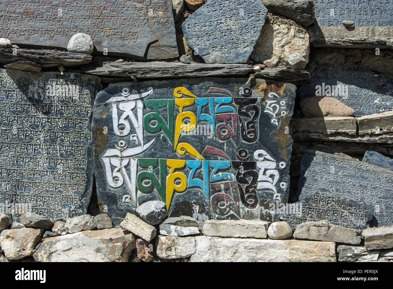 Colored inscriptions on stones in the mountains of Nepal on a Sunny day ...