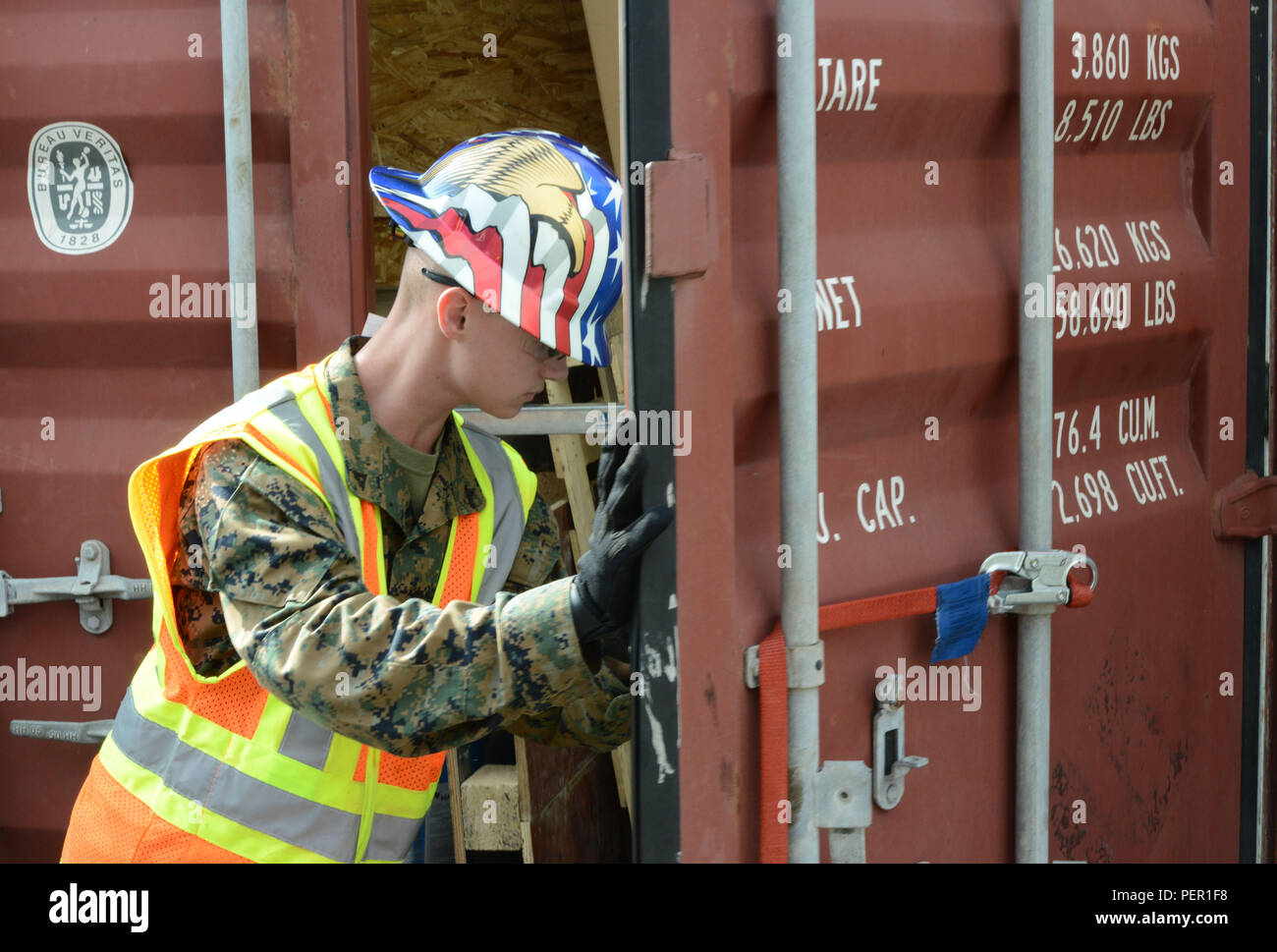 A Marine with the 3rd Marine Regiment opens a container door during ...