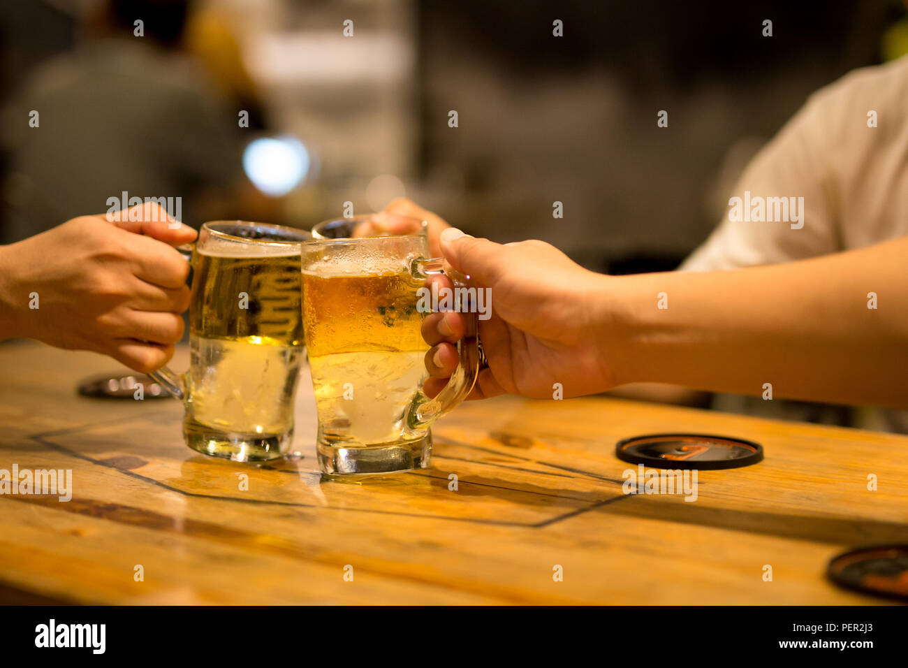 Shot in low light friends toasting with glasses beer at the pub Stock ...