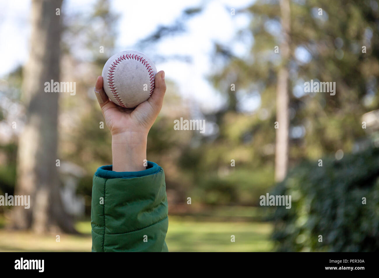 Children hand holding baseball in blur background Stock Photo - Alamy