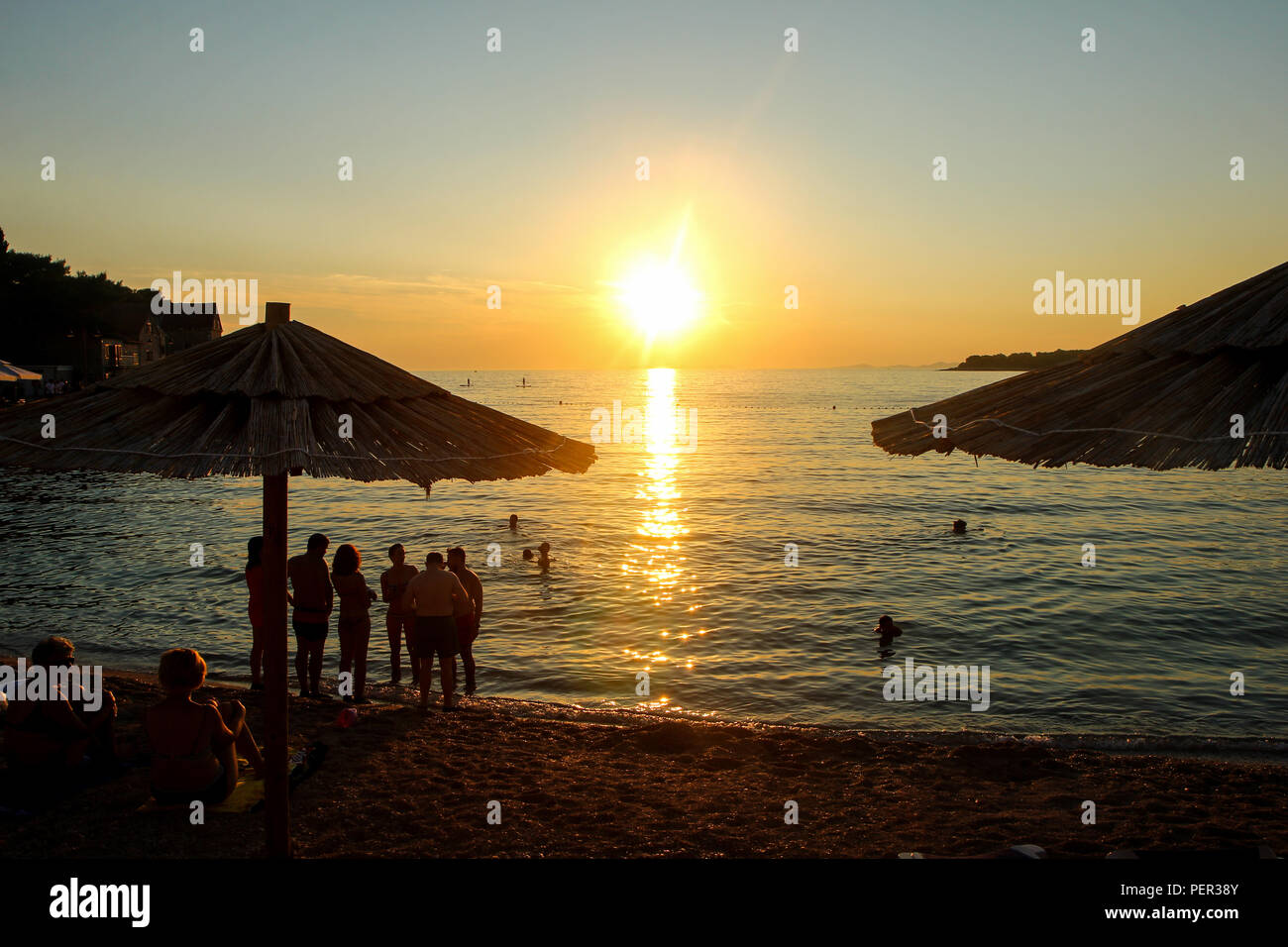 A picture from the beach during the sunset. People are enjoying the ...