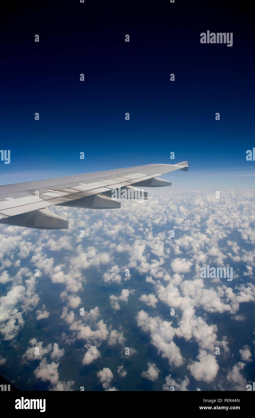 Blue sky above, clouds below the wing of a commercial jetliner Stock ...