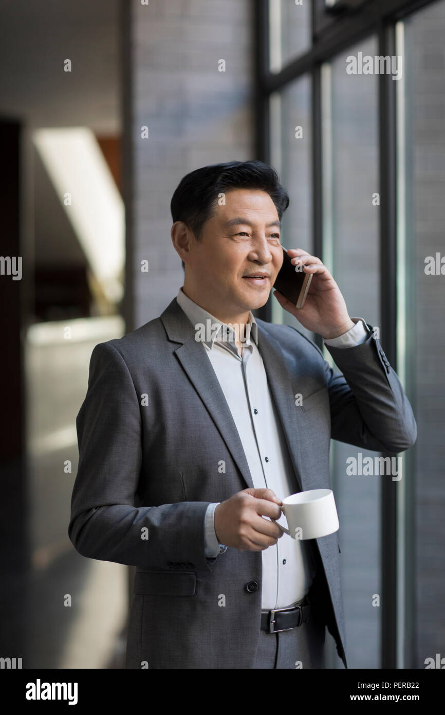 Confident businessman talking on cell phone Stock Photo - Alamy