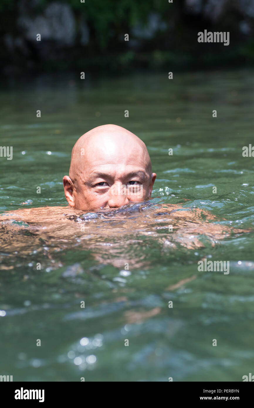 Japanese bald head guy emerging from water Stock Photo - Alamy