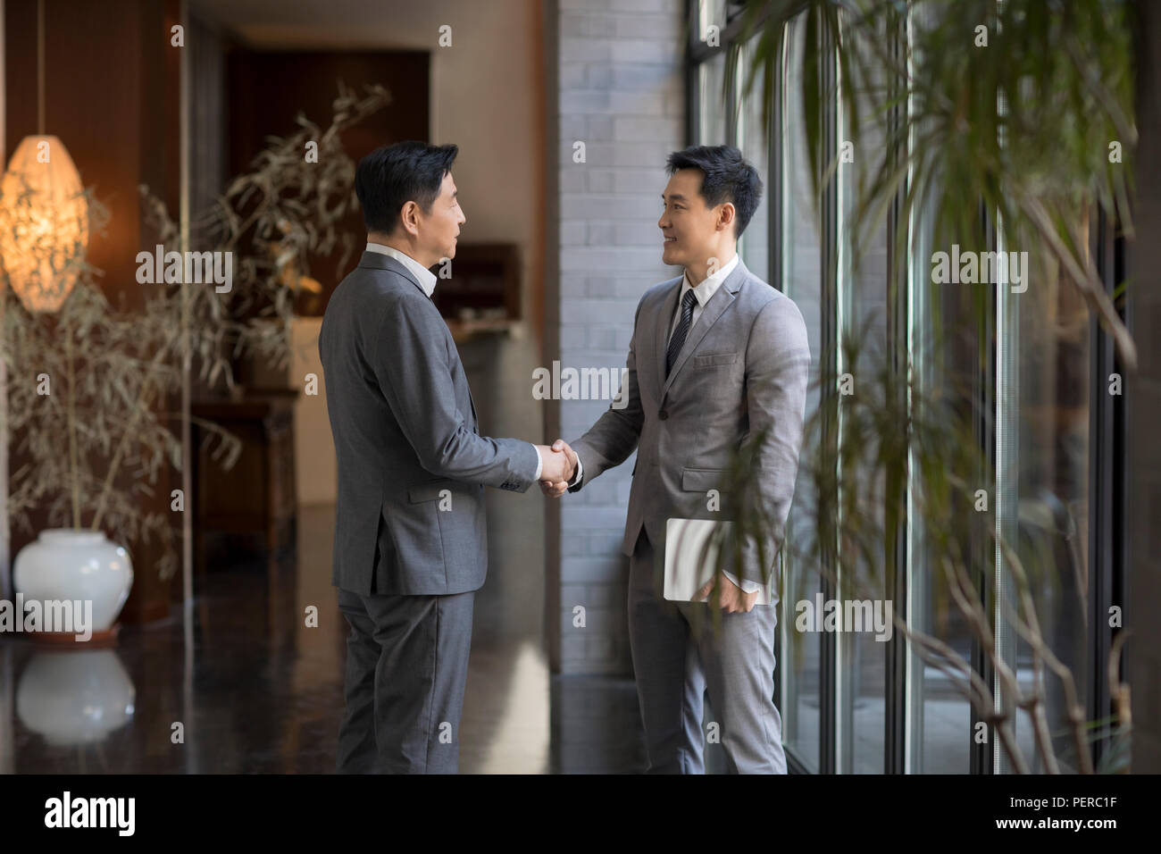 Standing greeting shaking hands smiling leadership face to face hi-res ...
