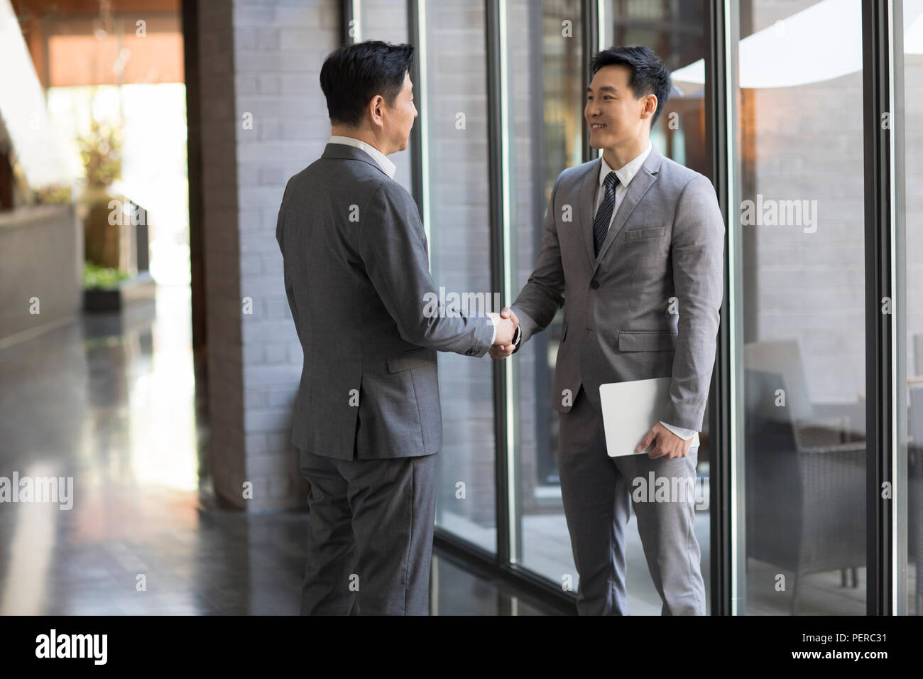 Standing greeting shaking hands smiling leadership face to face hi-res ...