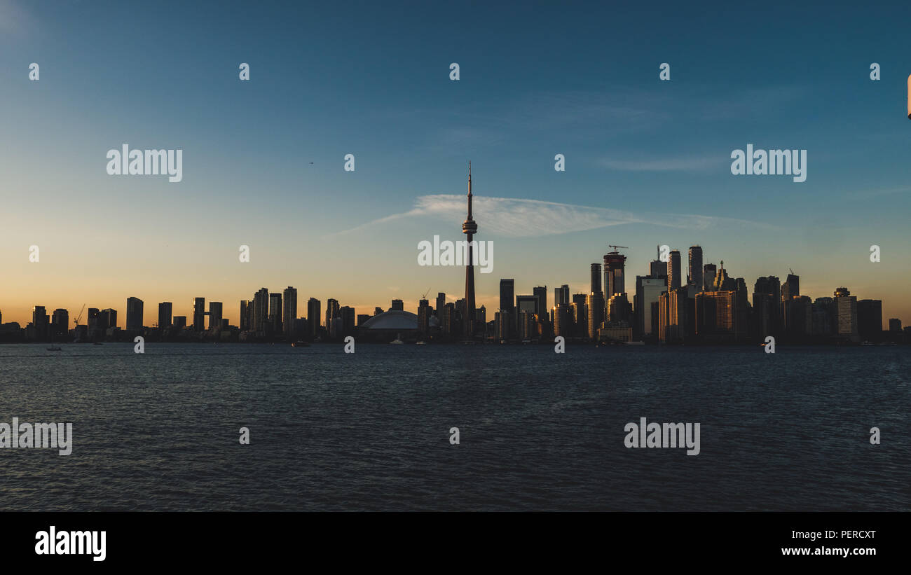 toronto skyline during sunset seen from toronto island with lake ...