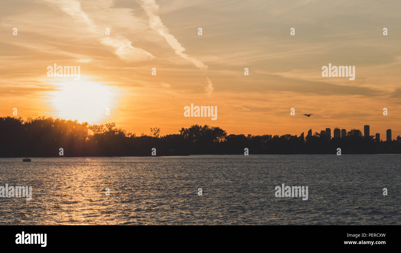 plane tacking off into sunset with lake infront beautiful scene with ...