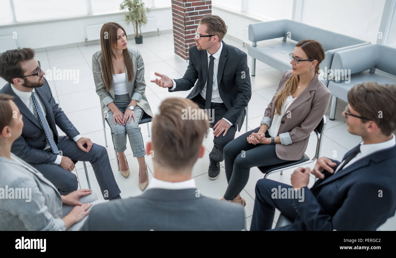 employees of the company sitting in a circle and discussing work ...
