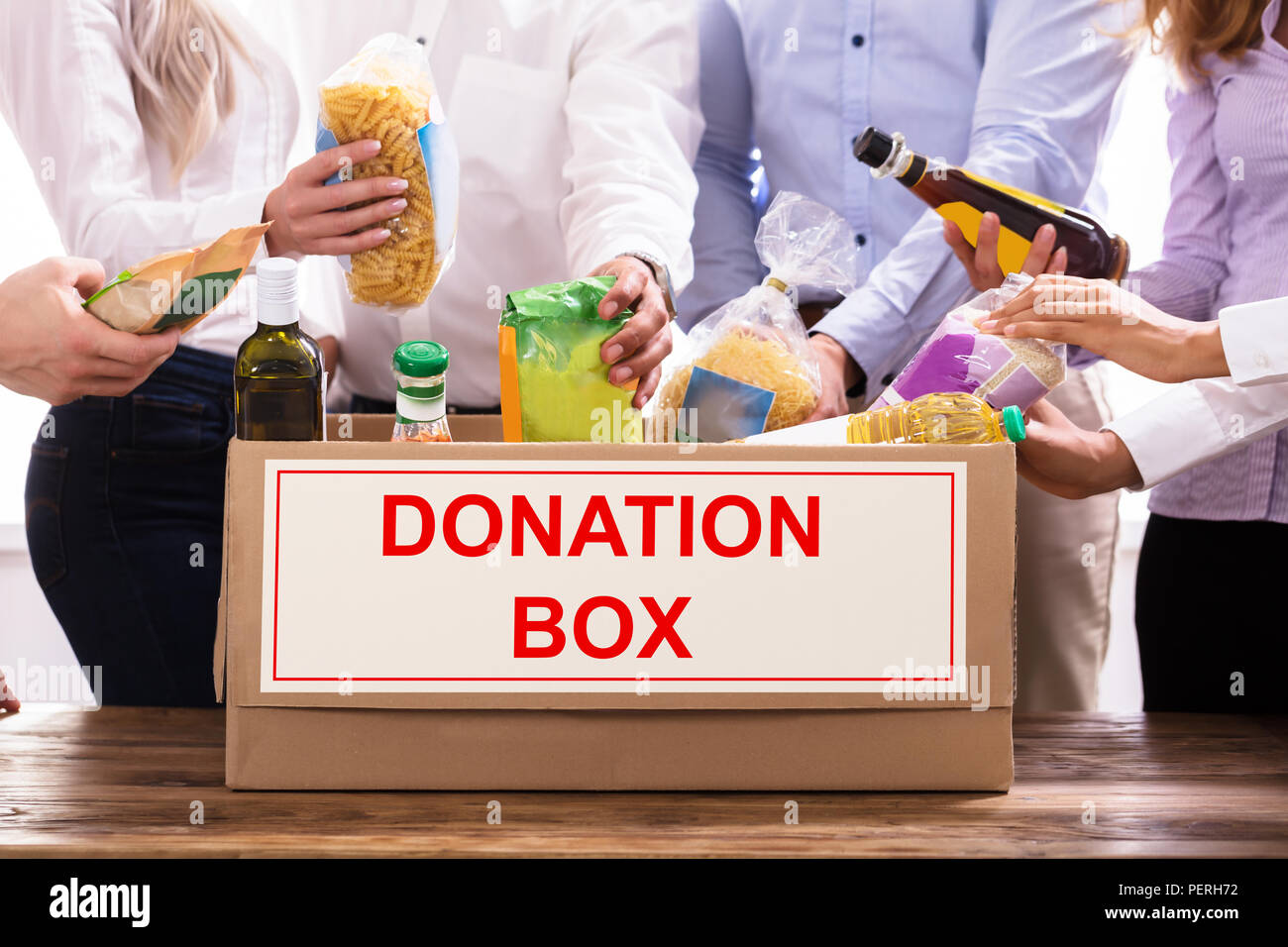 Group Of People Donating Food In Donation Box Stock Photo - Alamy