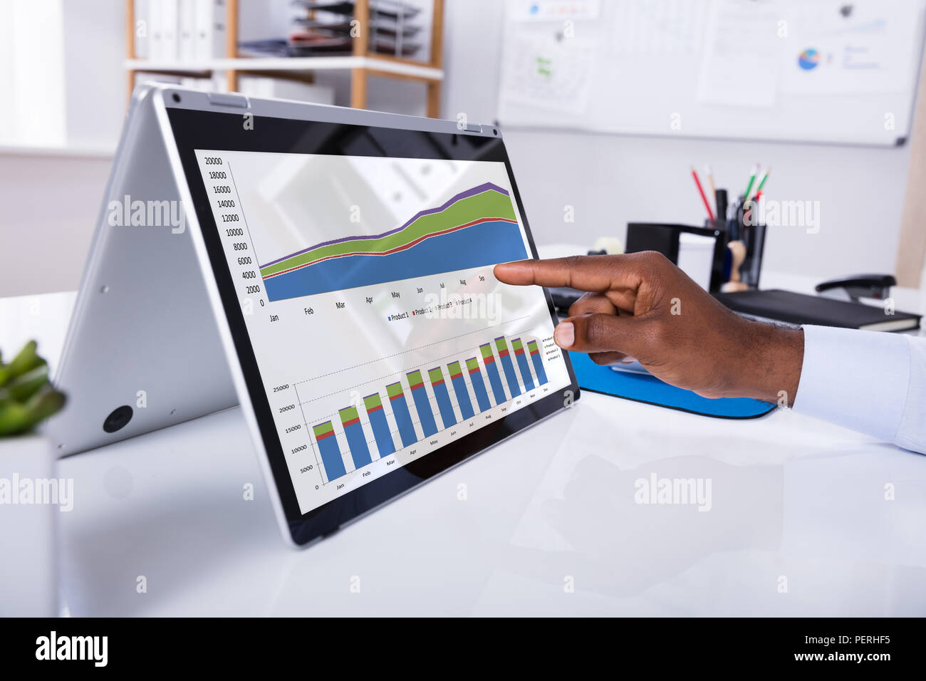 Businessman's Hand Pointing On Laptop Screen Showing Graph Over The ...