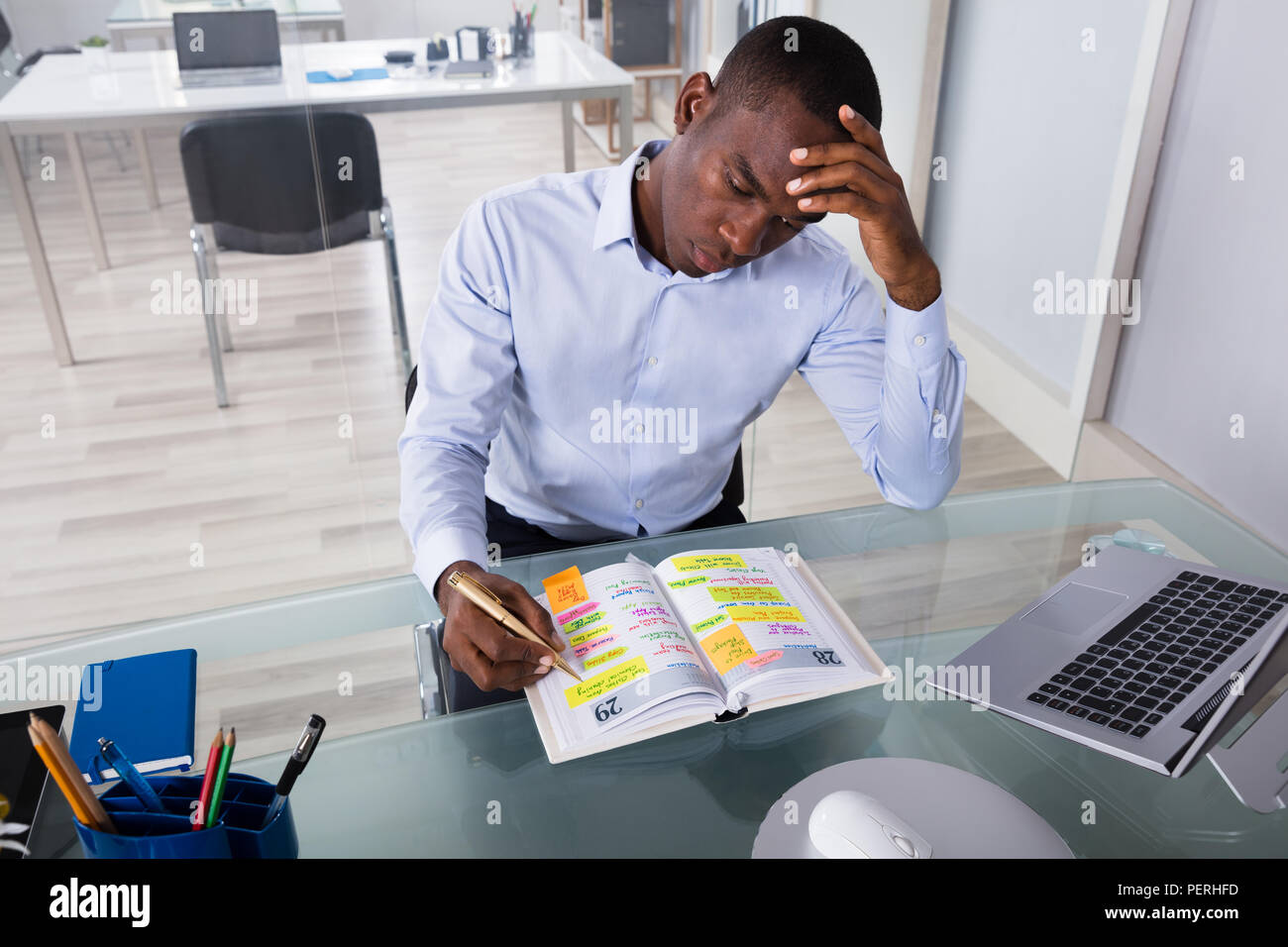 Overhead View Of Worried Businessman Writing Schedule In The Diary On ...