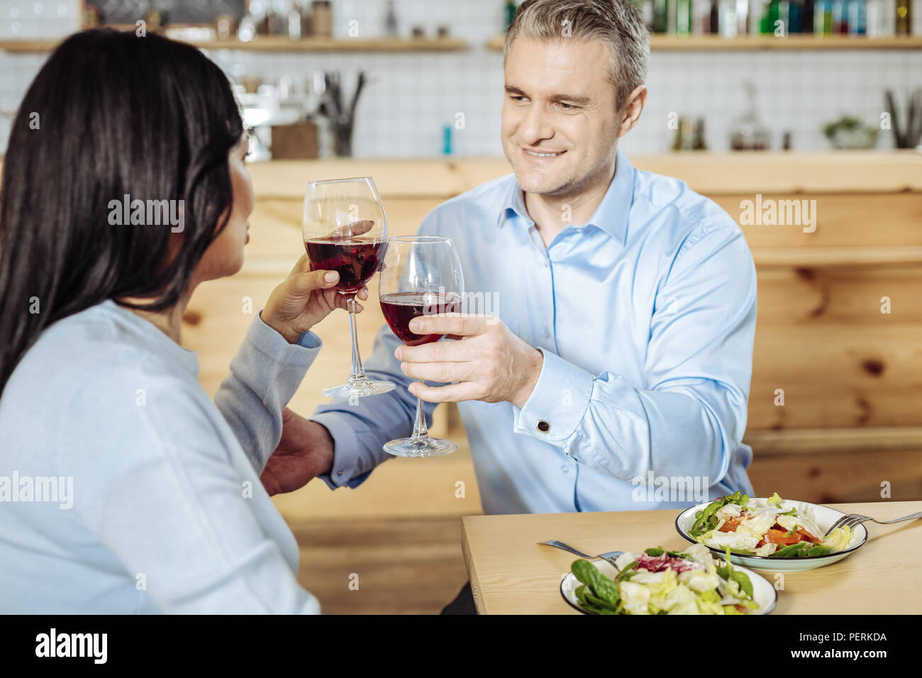 High-spirited man and woman raising glasses Stock Photo - Alamy