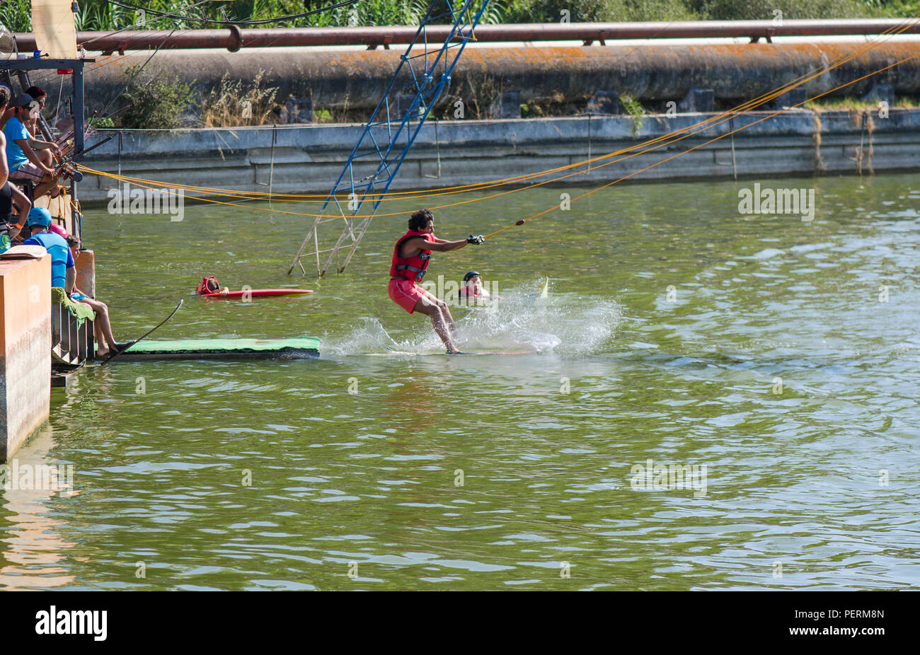 Teenage boy wakeboarding, skurfing, water skiing, on a lake, Wake Park ...