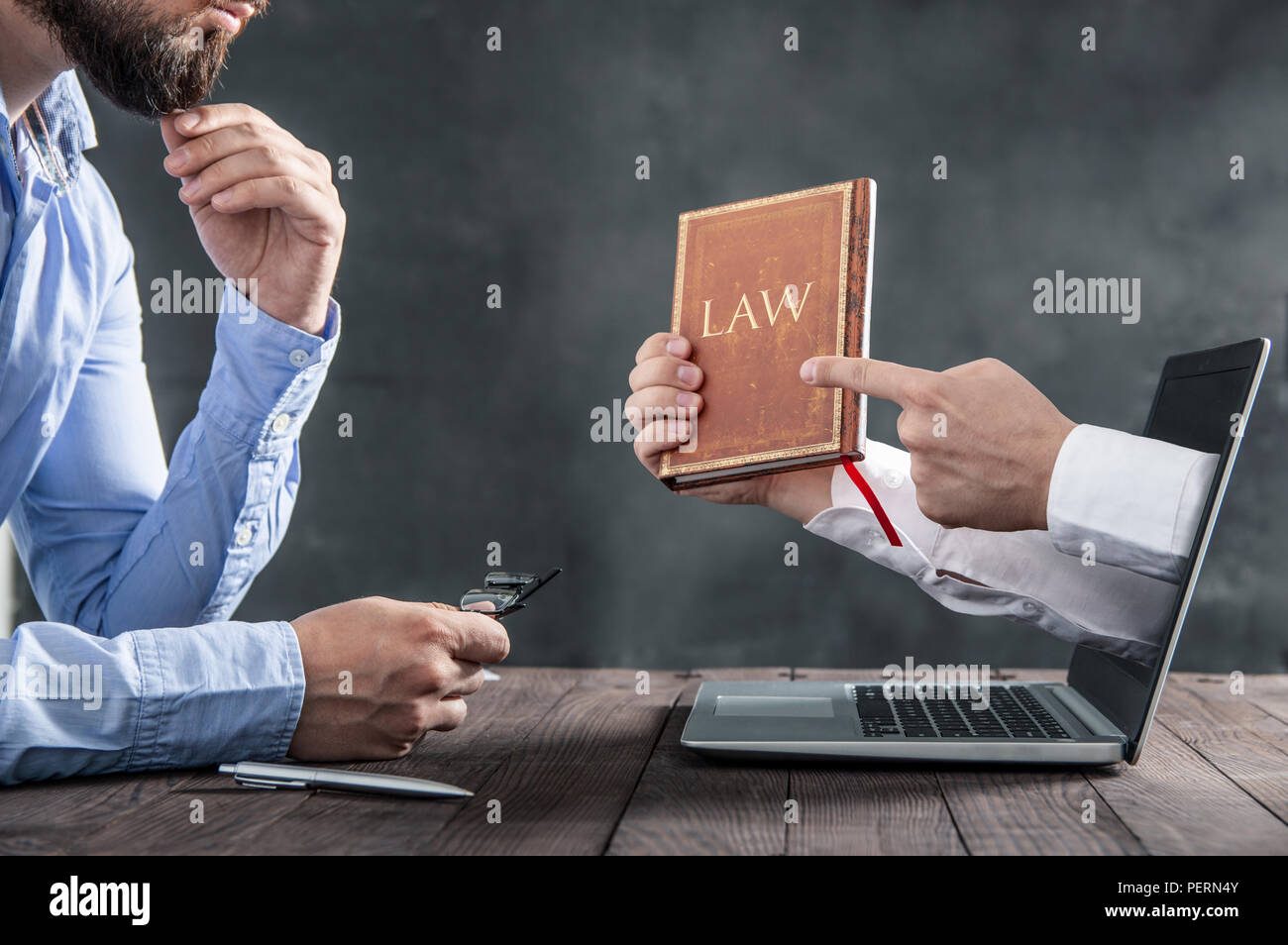 Man is looking at the hands coming out of the laptop that holds a book ...