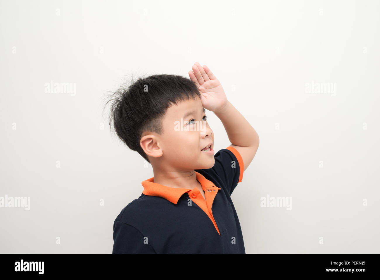 Cute little boy showing a saluting gesture in the studio Stock Photo ...