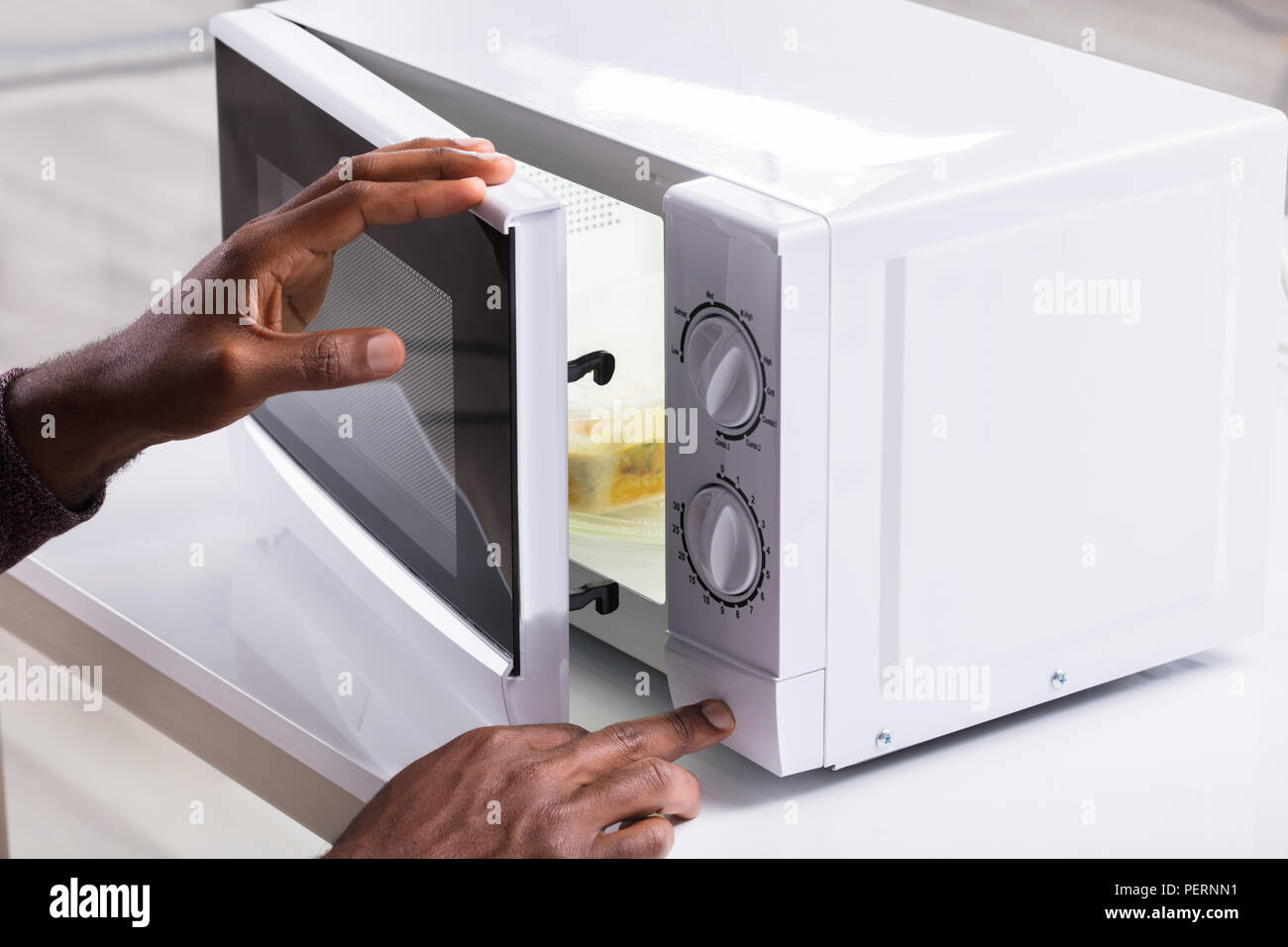 Close-up Of A Man's Hand Heating Food In Microwave Oven Stock Photo - Alamy
