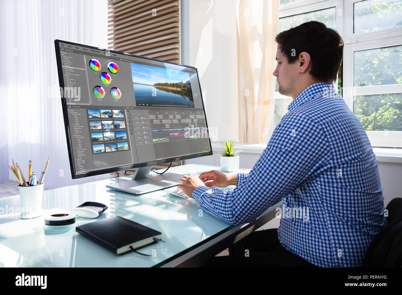 Young male editor editing video on computer at workplace Stock Photo ...