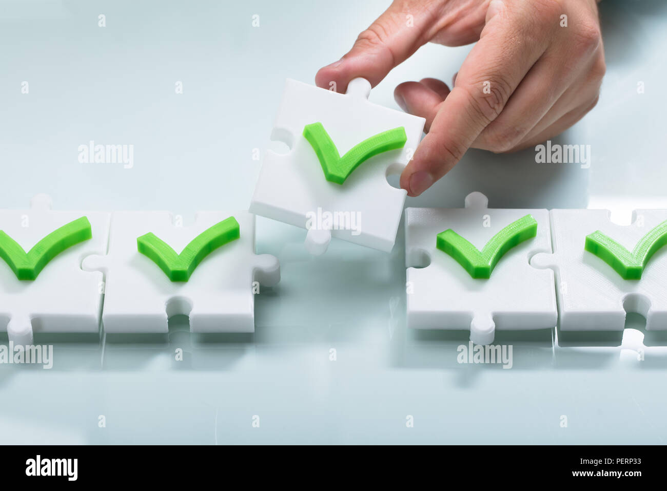 Close-up of a person's hand arranging green check mark sign in a row ...