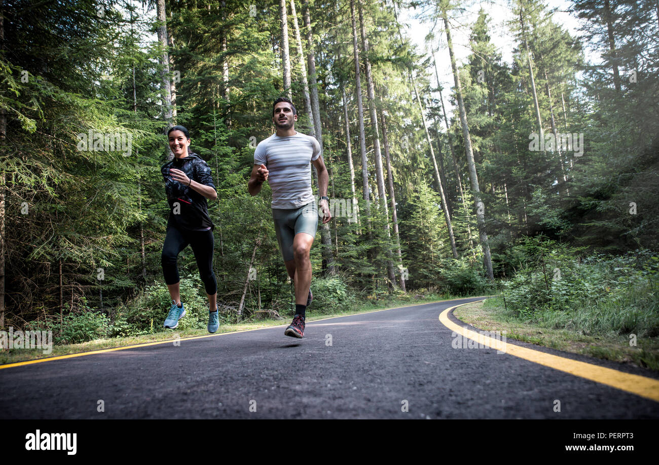 Couple running in the forest Stock Photo - Alamy