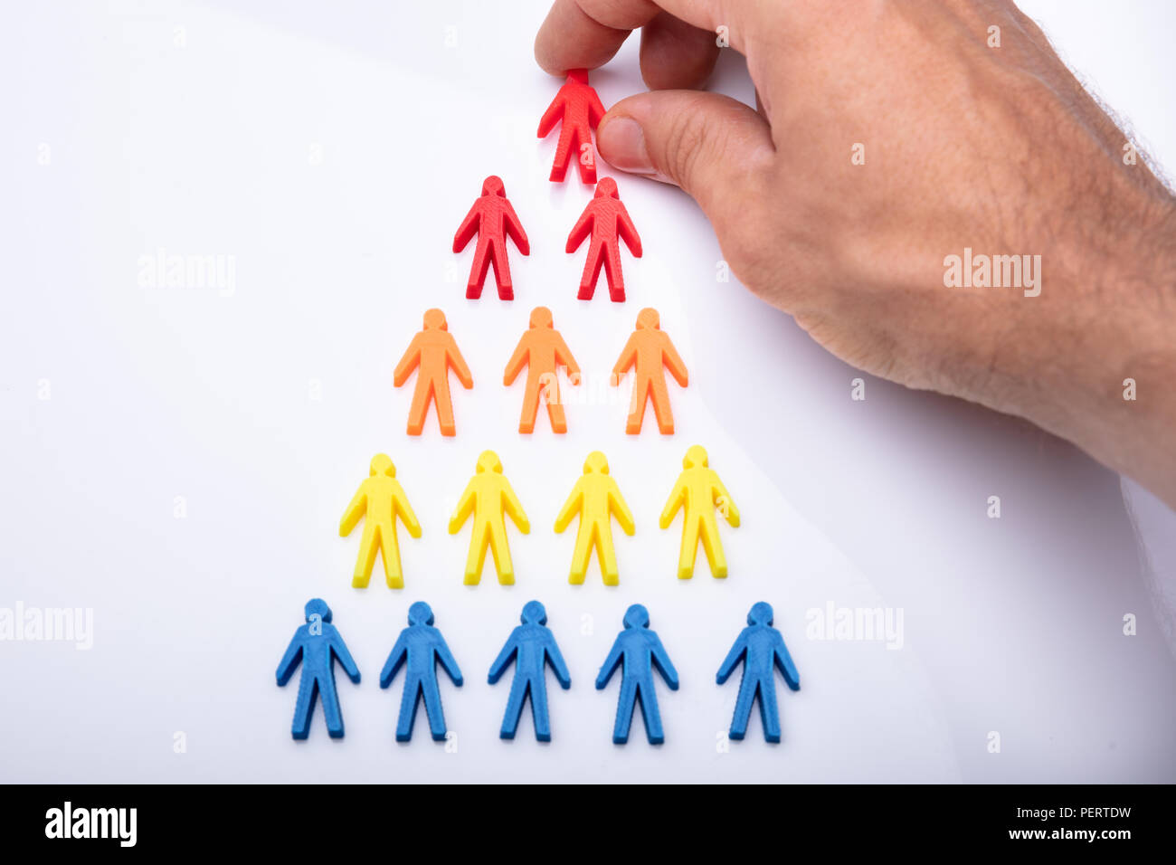 Elevated View Of A Man's Hand Making Pyramid Of Human Figures Stock ...