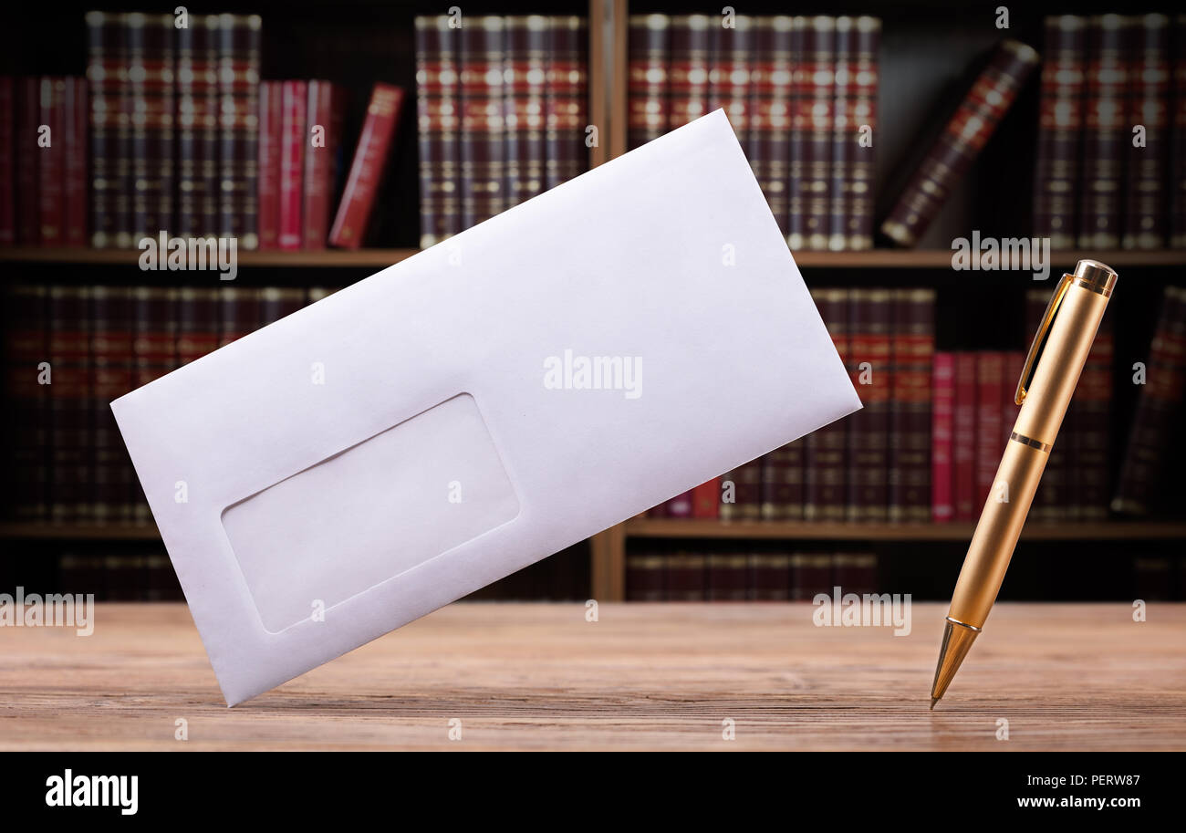 Crossed Pen And Envelope On Wooden Desk Stock Photo - Alamy